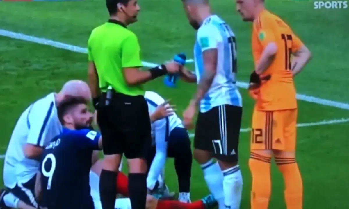 Lachende Otamendi pakt bidon van Giroud af en spuit boze Fransman nat